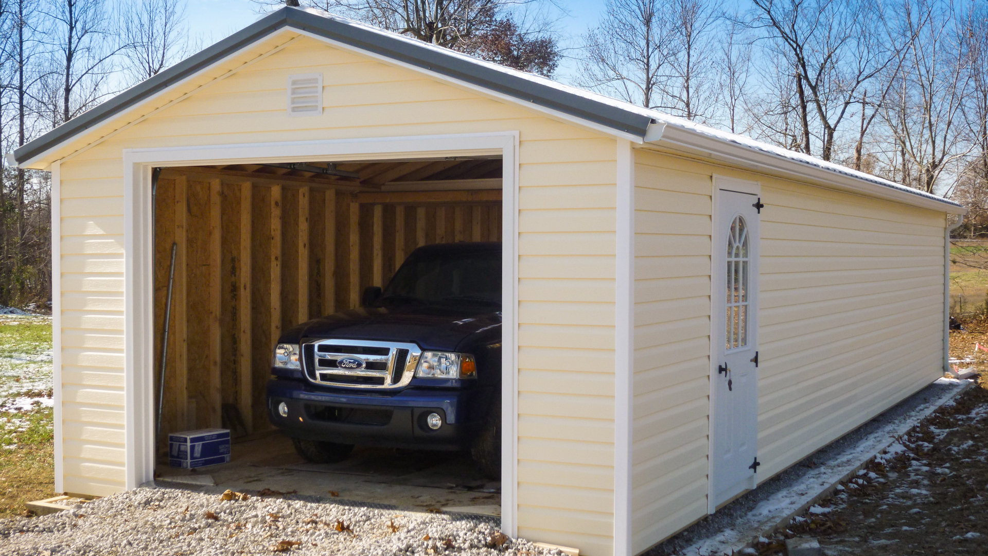 exterior of yellow garage shed with car - Esh's Utility Buildings